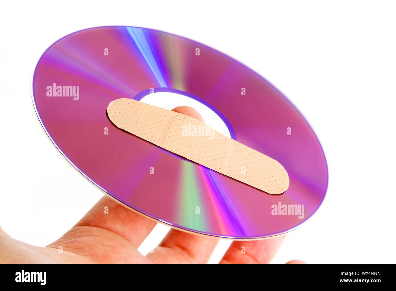 A compact disk or dvd with a bandage on it. Isolated on white with ...