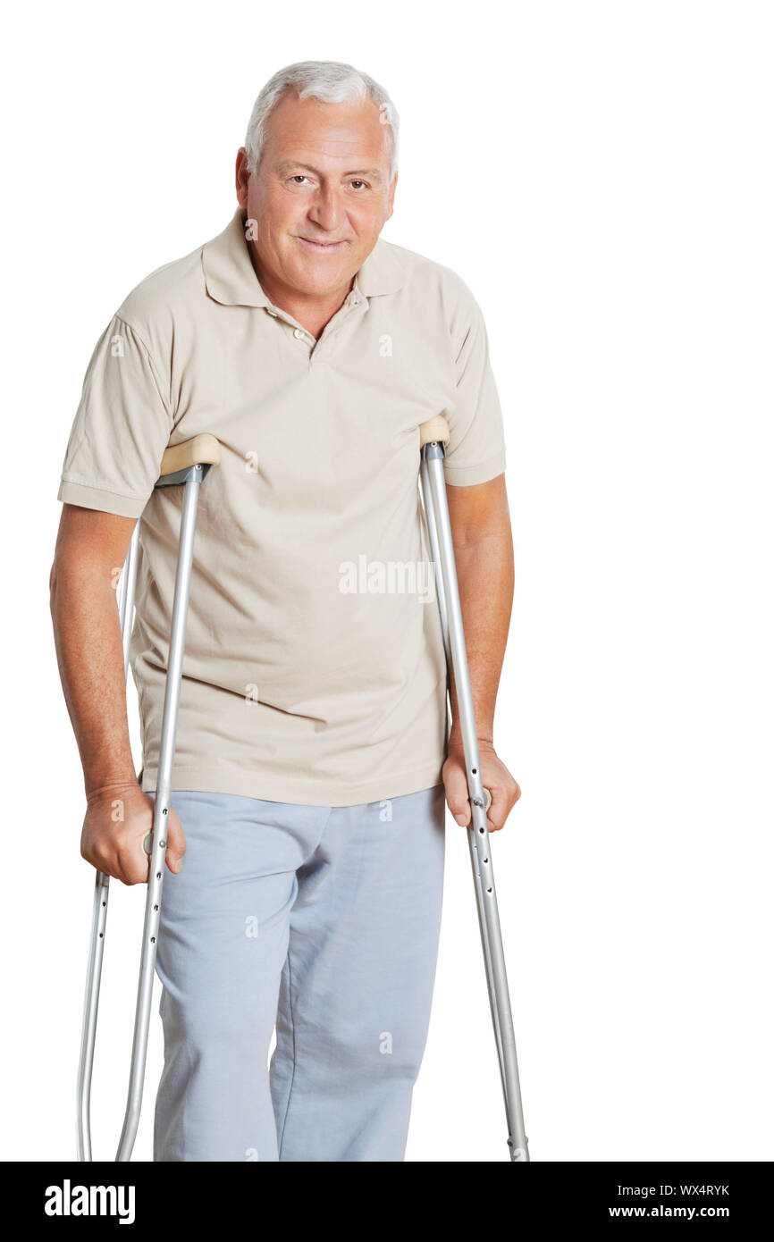 Portrait of happy senior man on crutches isolated over white background ...