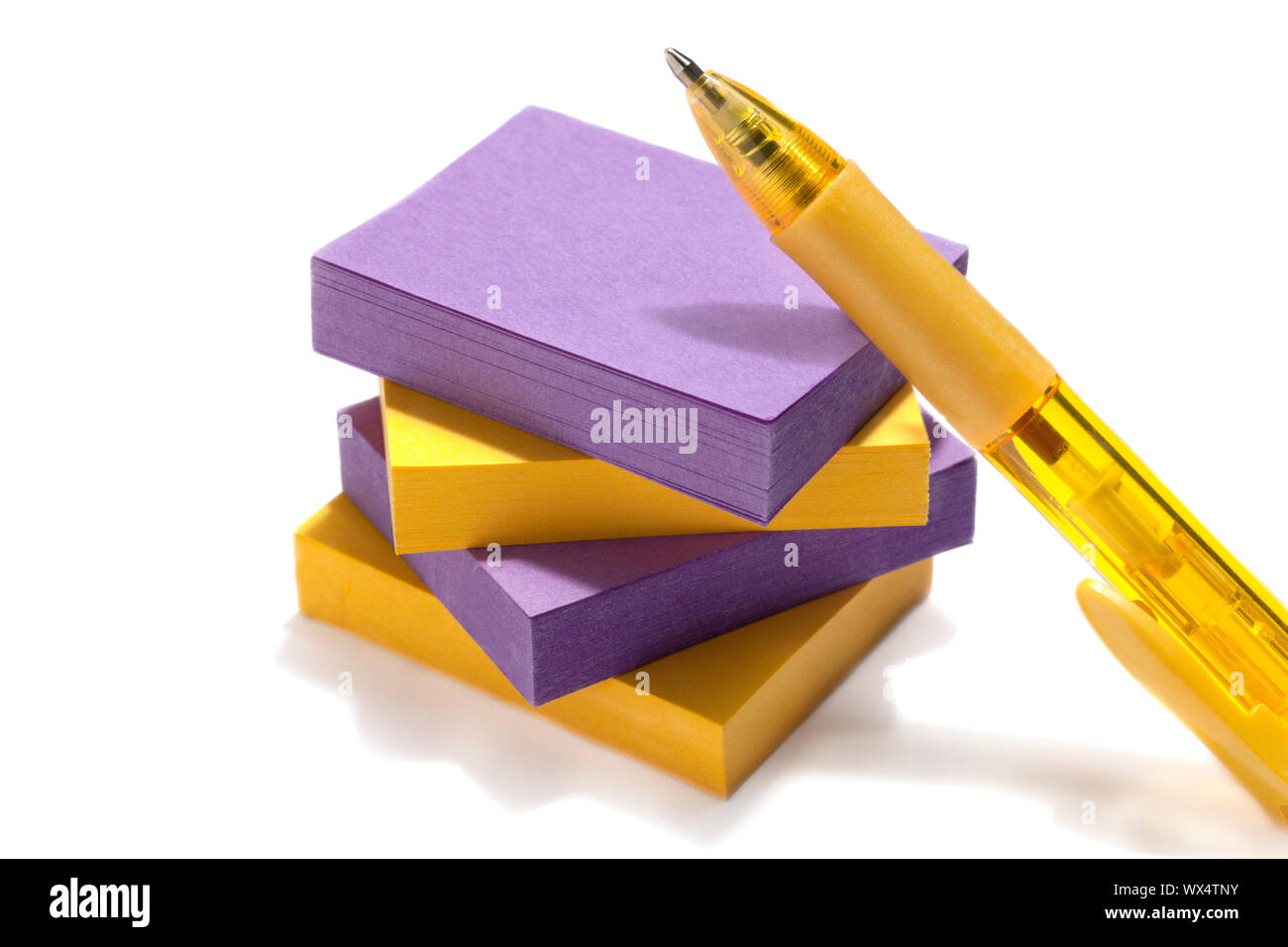 Stack of colorful post-it notes with yellow pen on a white background ...