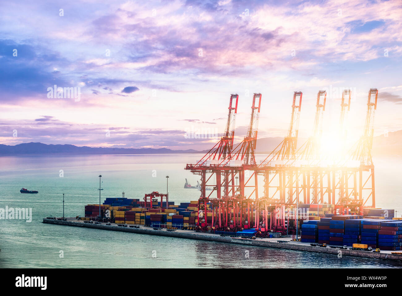 Cargo ship in the harbor at sunset Stock Photo - Alamy