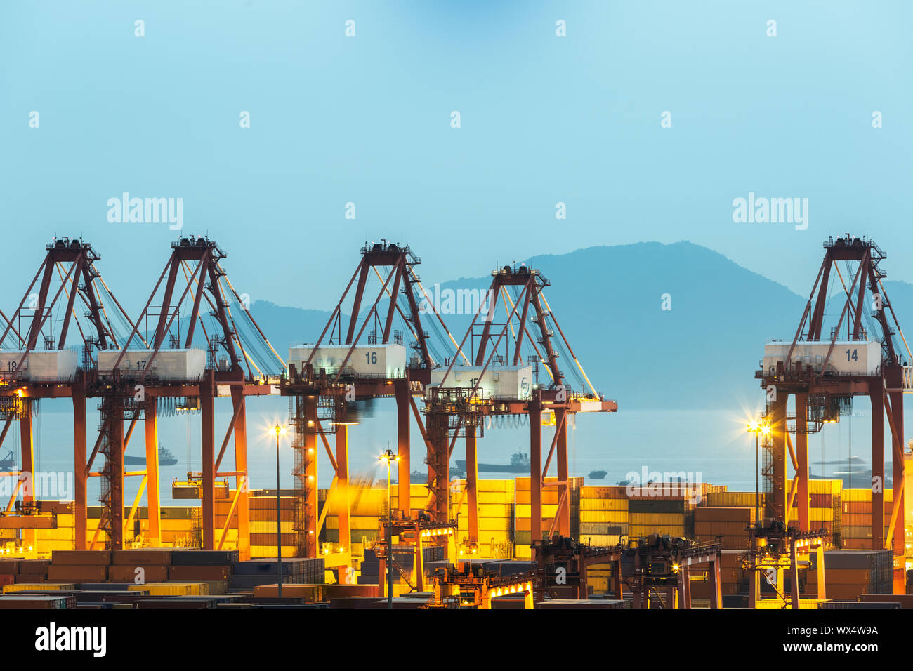 Cargo ship in the harbor at sunset Stock Photo - Alamy