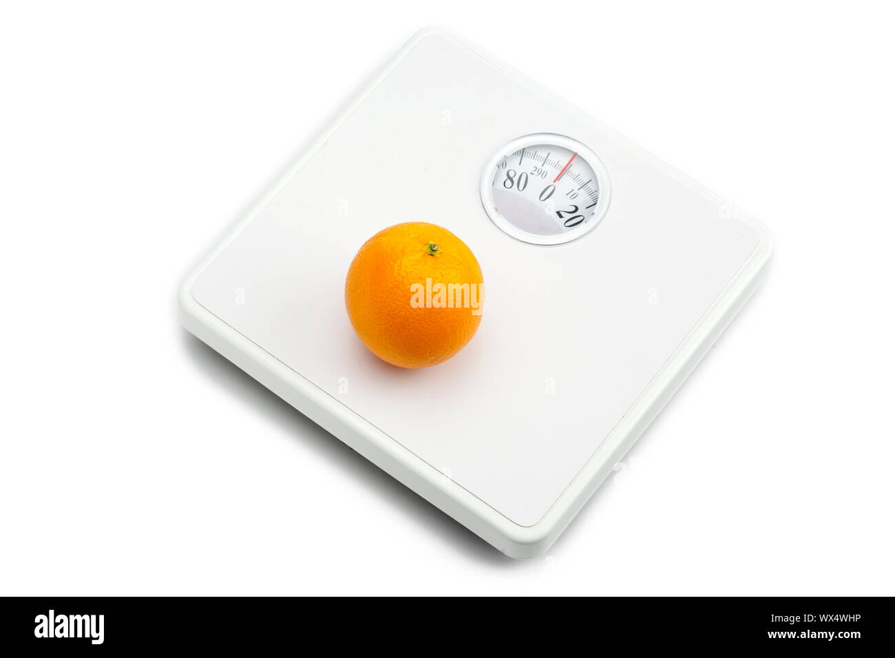 Weighing scale and orange fruit on white Stock Photo - Alamy