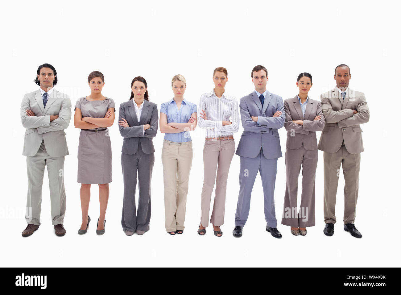 Serious business team side by side crossing their arms against white background Stock Photo - Alamy