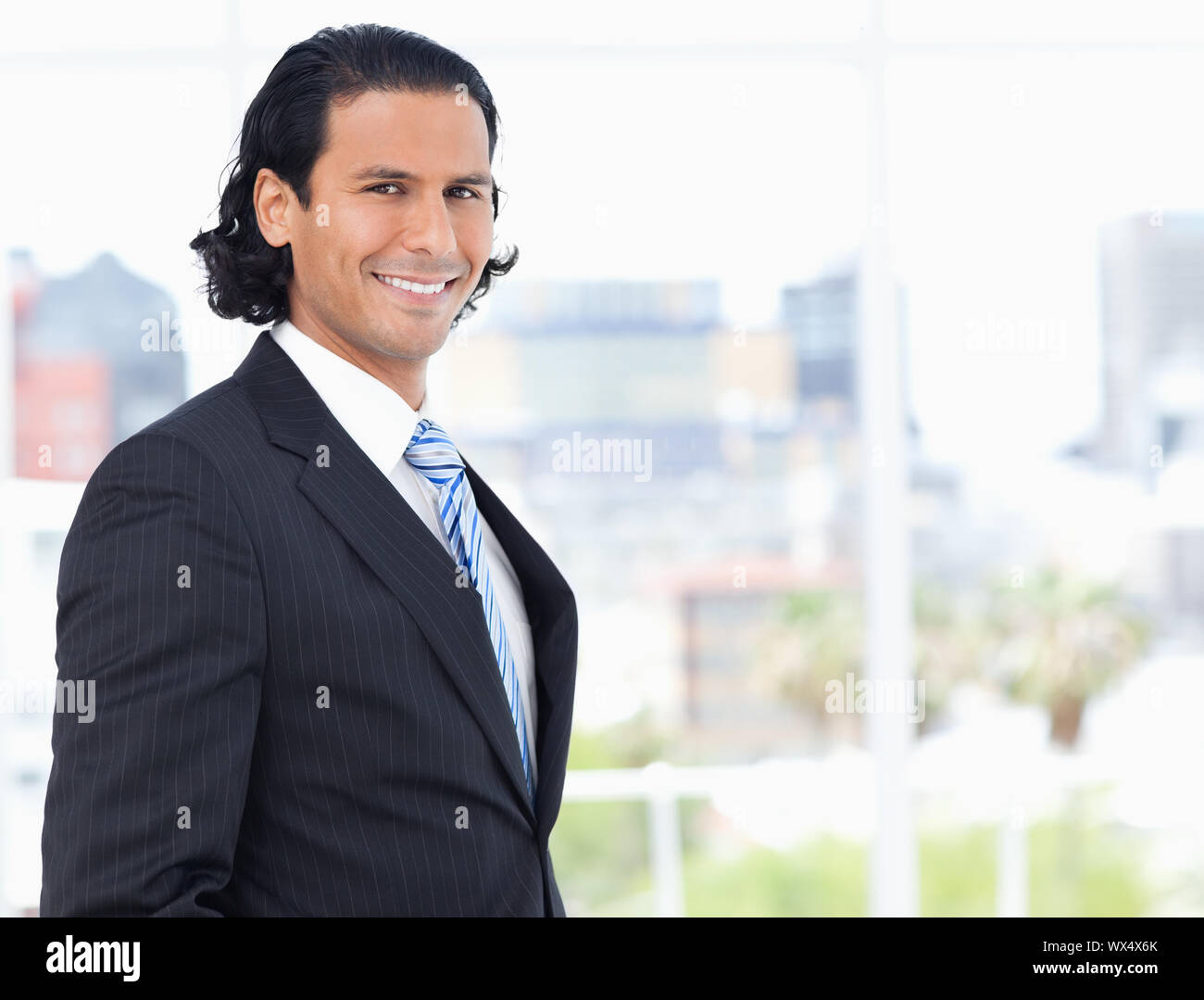 Executive proudly standing in front of a window Stock Photo - Alamy