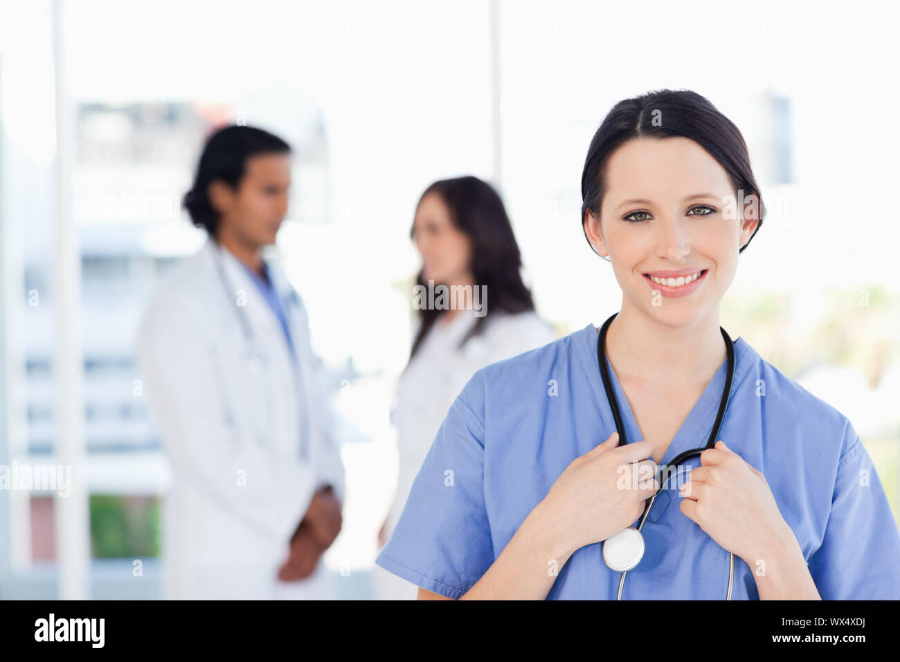 Confident intern standing in front of her medical team Stock Photo - Alamy