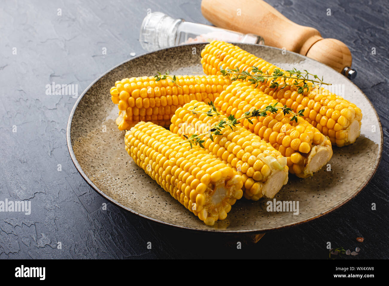 Tasty boiled corn cobs with butter, thyme and salt on plate Stock Photo ...
