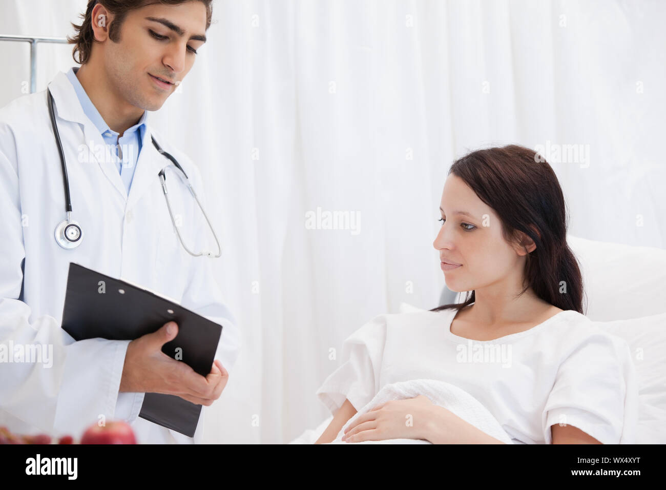 Doctor showing sheets to a patient in a hospital Stock Photo - Alamy