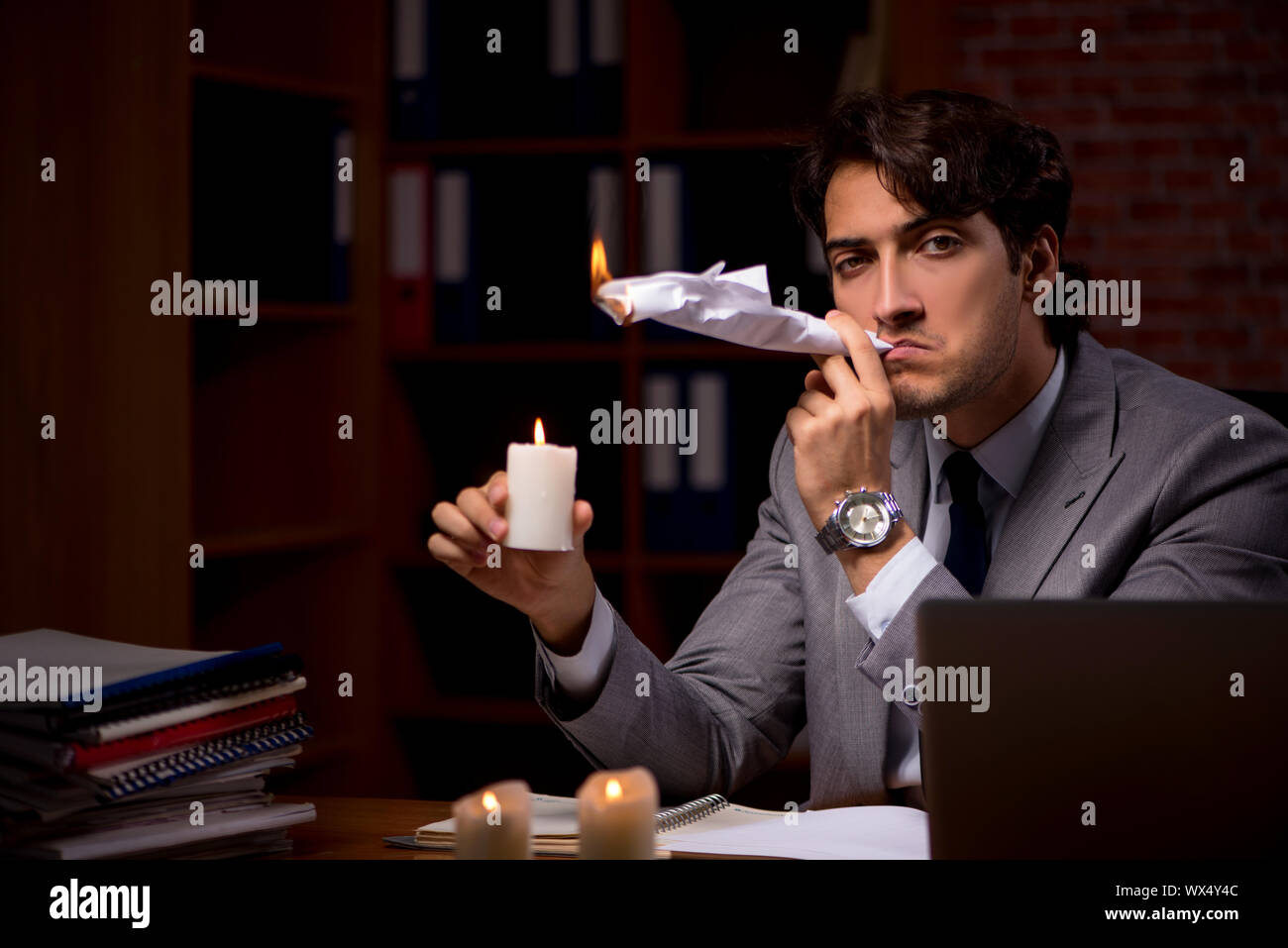 Businessman burning the evidence late in office Stock Photo - Alamy