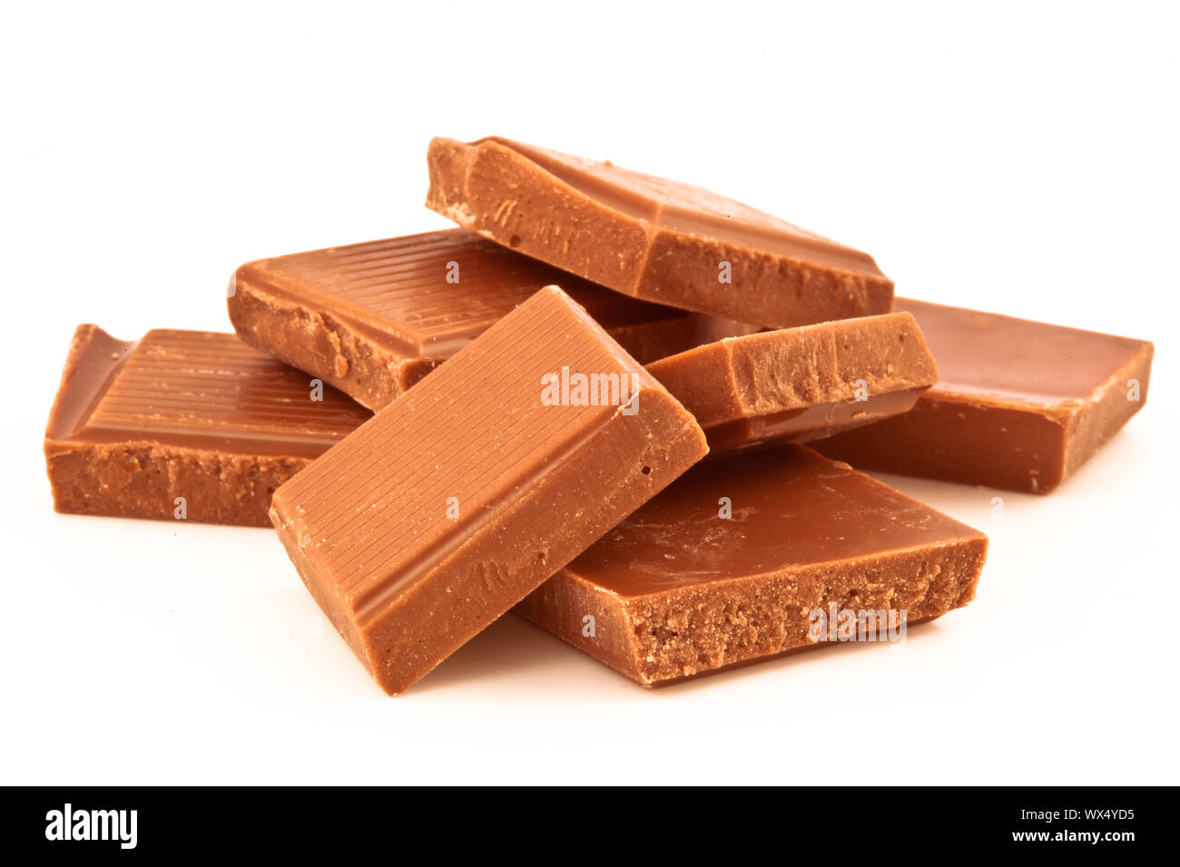 Many pieces of milk chocolate against a white background Stock Photo ...