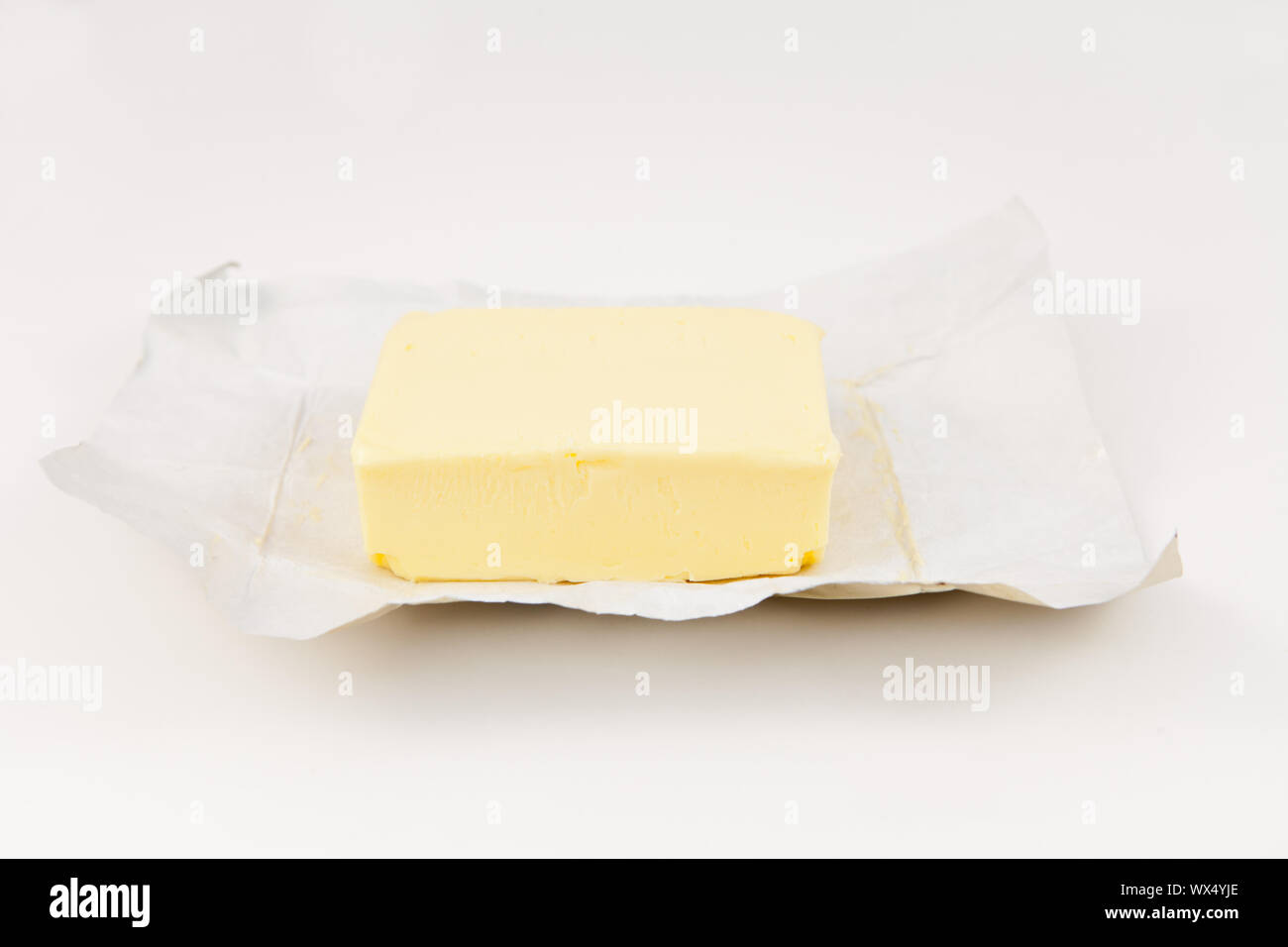 Open pat of butter against white background Stock Photo - Alamy