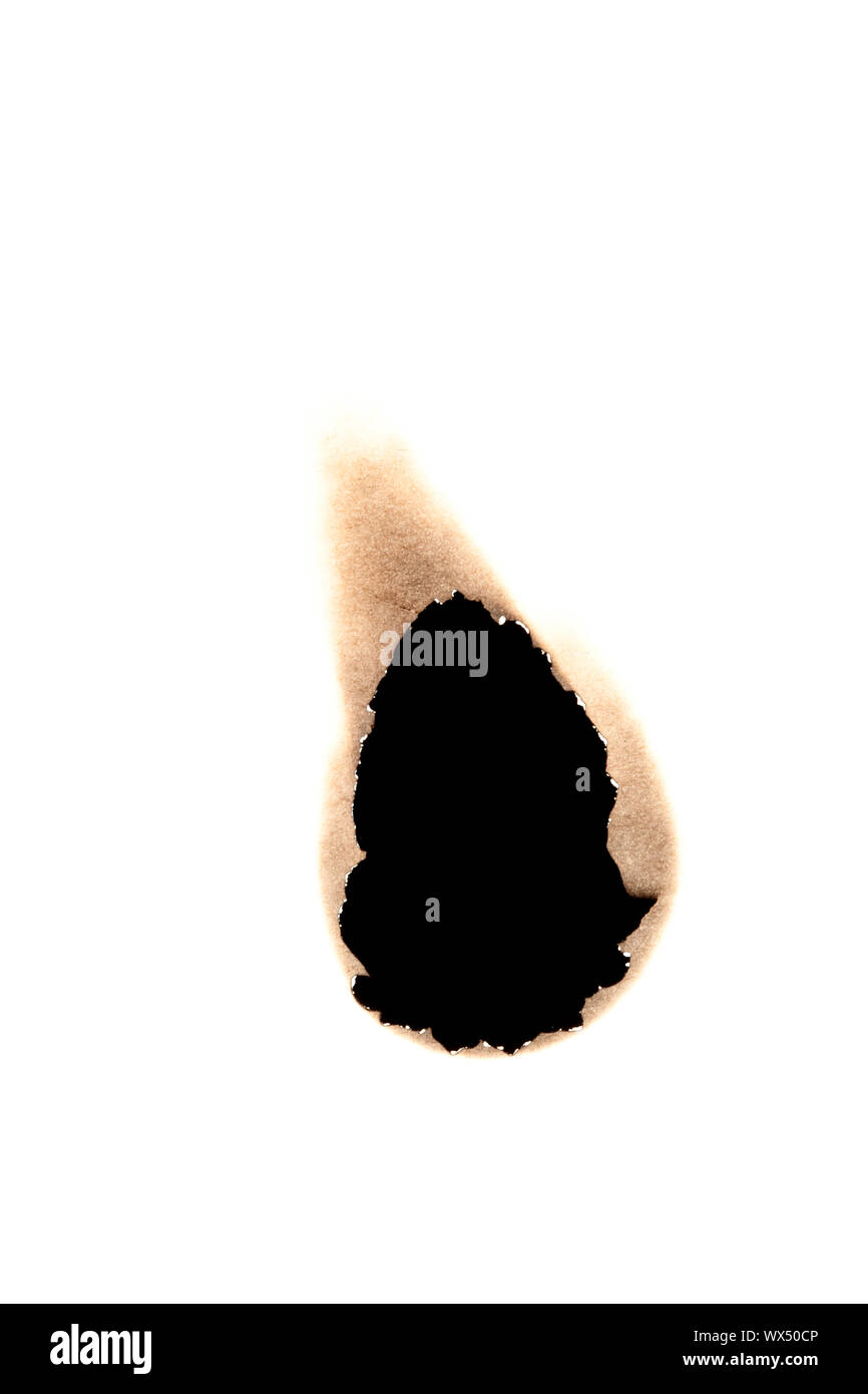 Small burned hole in paper against a white background Stock Photo - Alamy