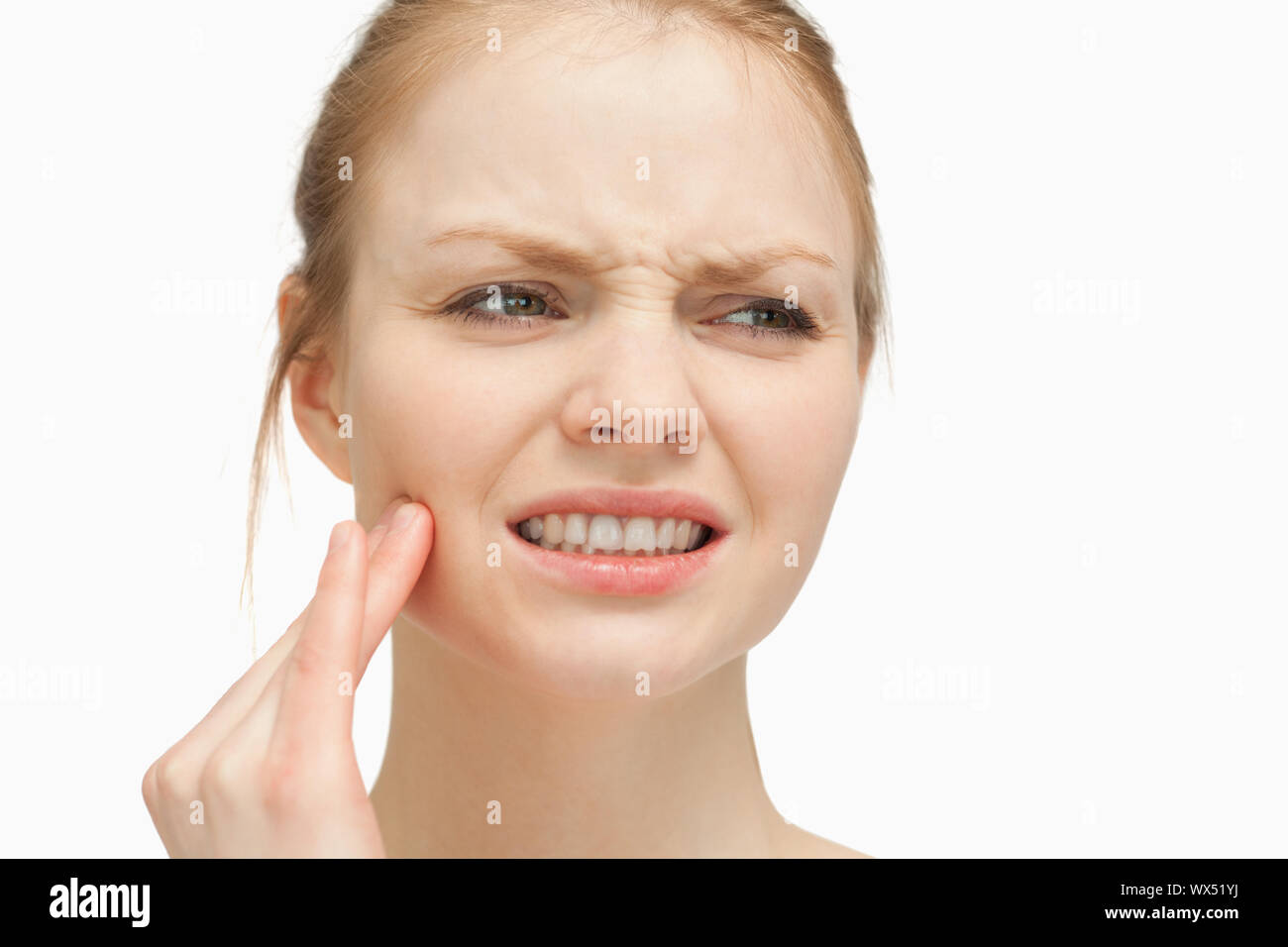 Woman massaging her cheek against white background Stock Photo - Alamy