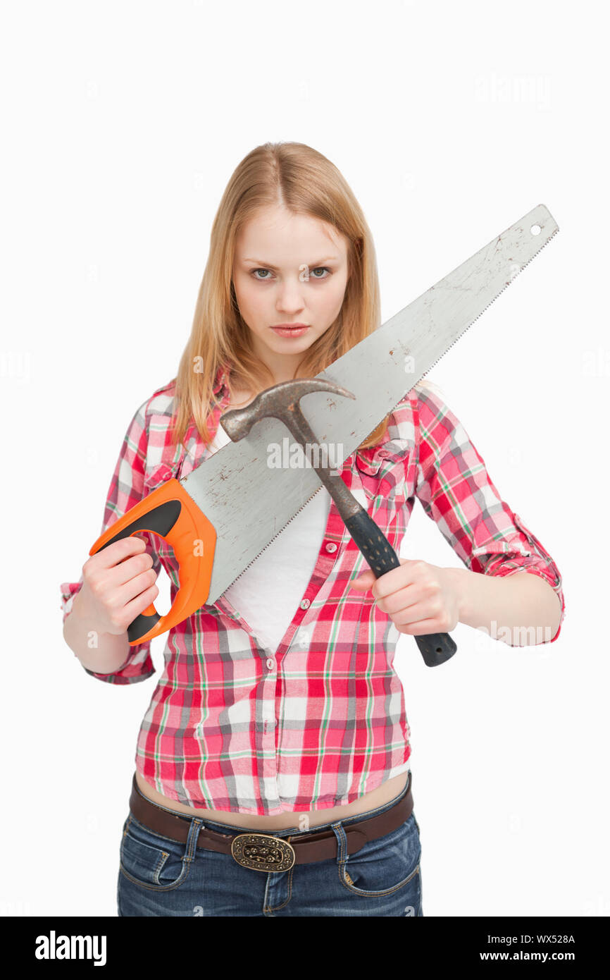 Woman holding a saw and a hammer against white background Stock Photo ...