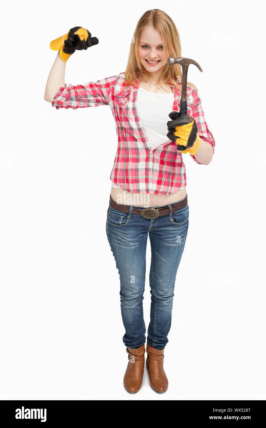 Woman standing while holding a hammer against white background Stock ...