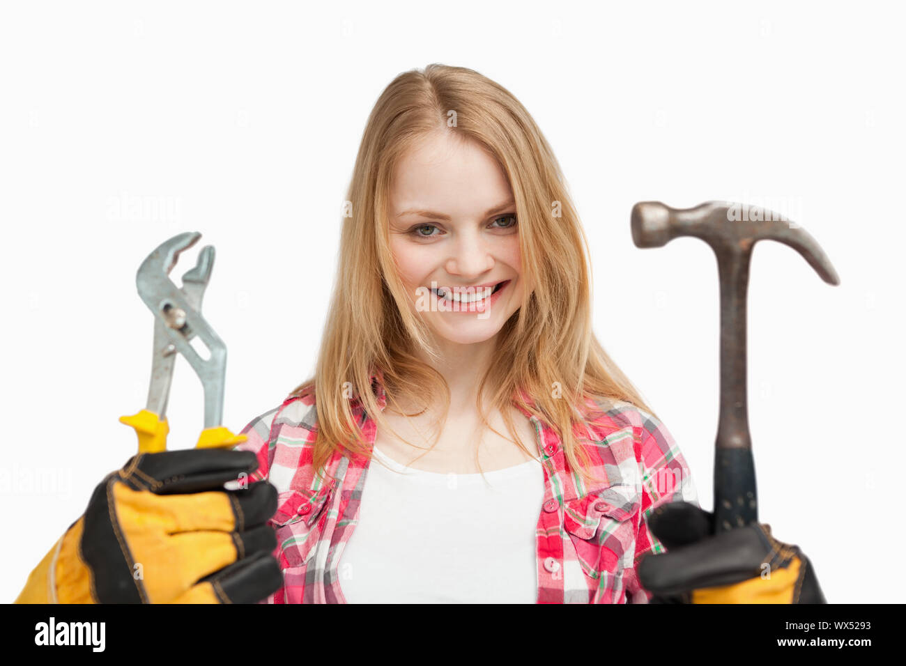 Woman holding tools while standing against white background Stock Photo ...