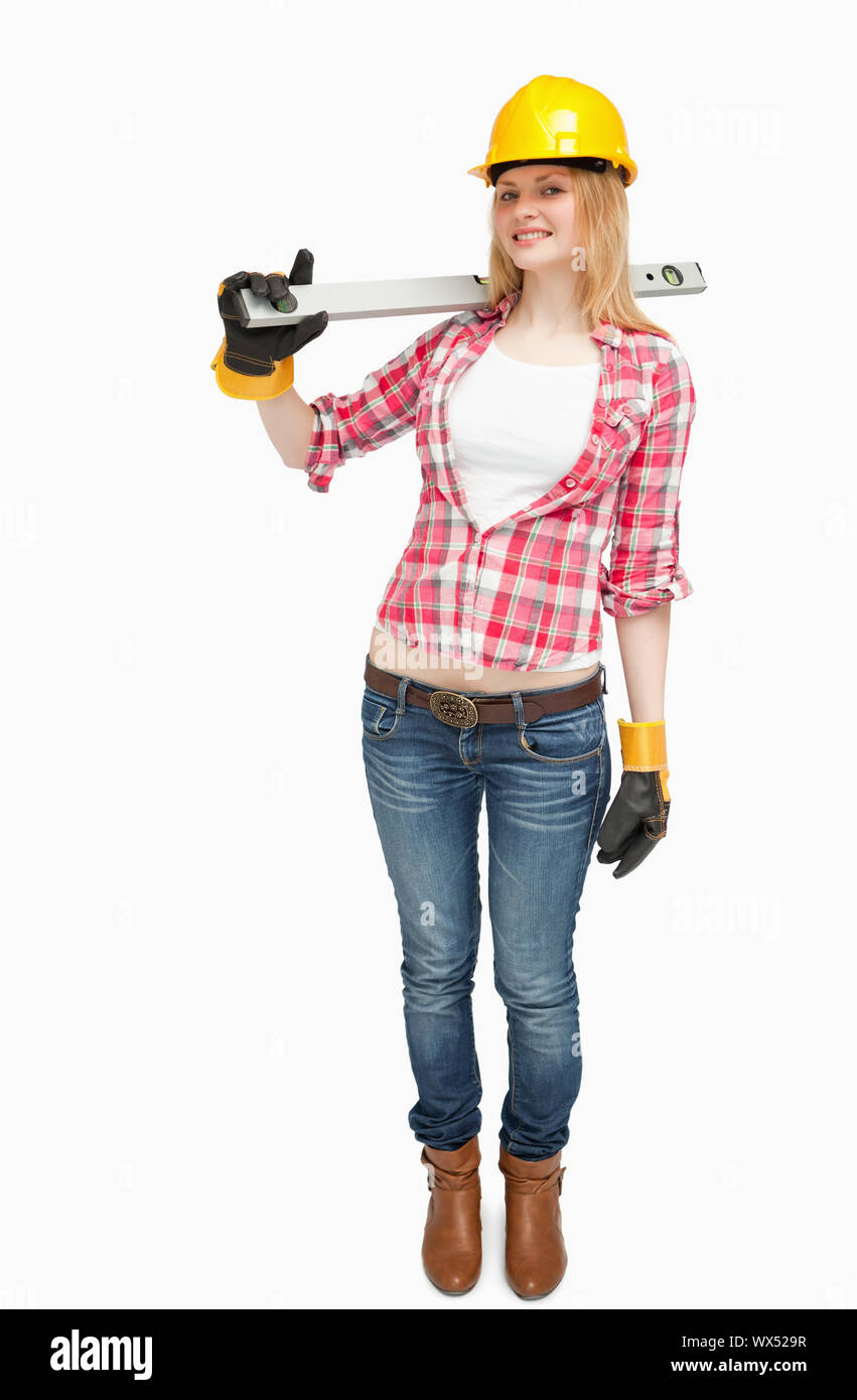 Joyful woman holding a spirit level against white background Stock ...