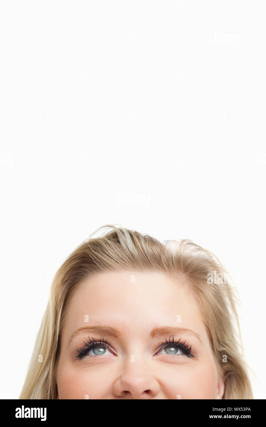 Joyful blonde woman looking up against a white background Stock Photo ...
