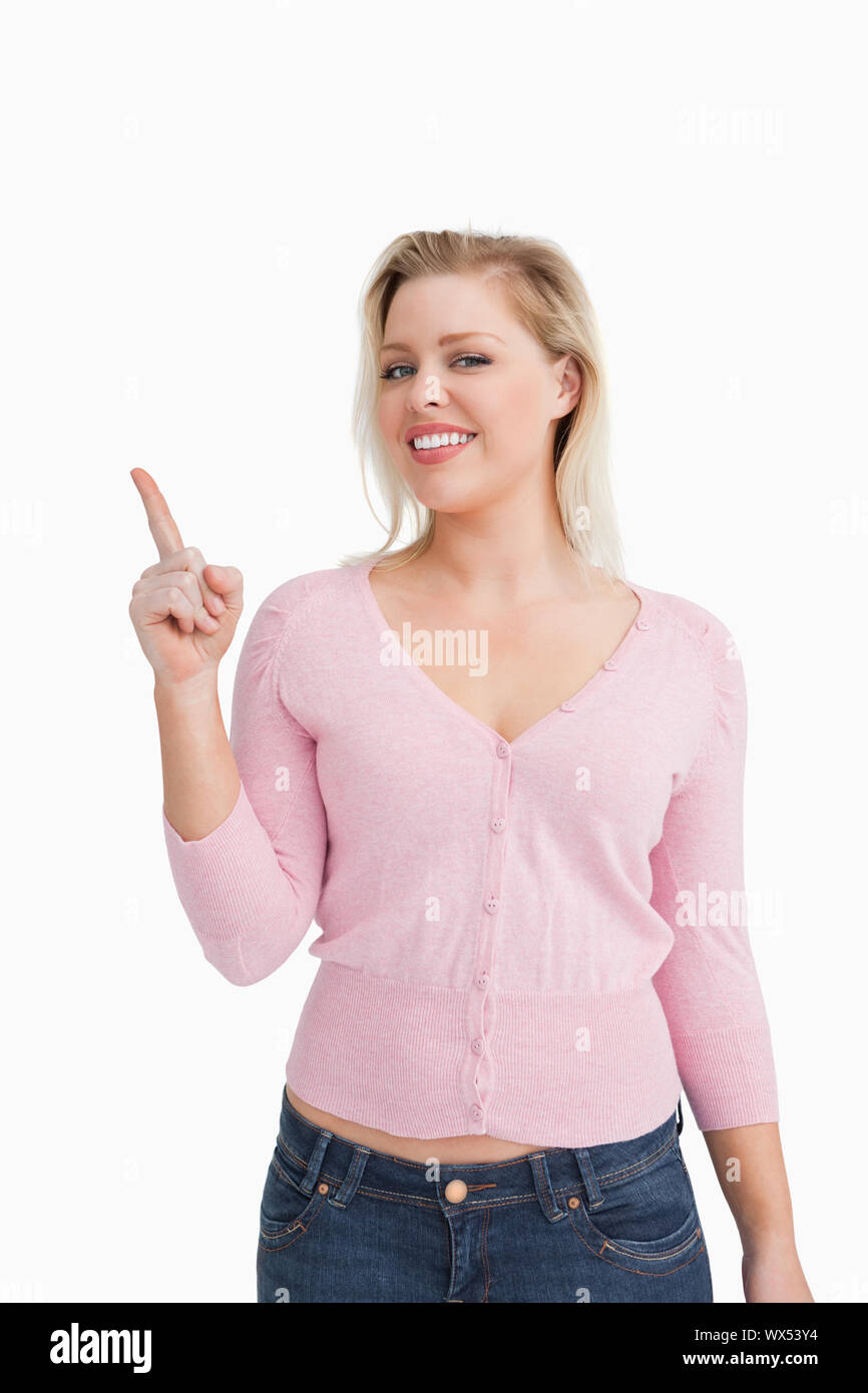 Happy woman raising her finger while pointing it against a white ...
