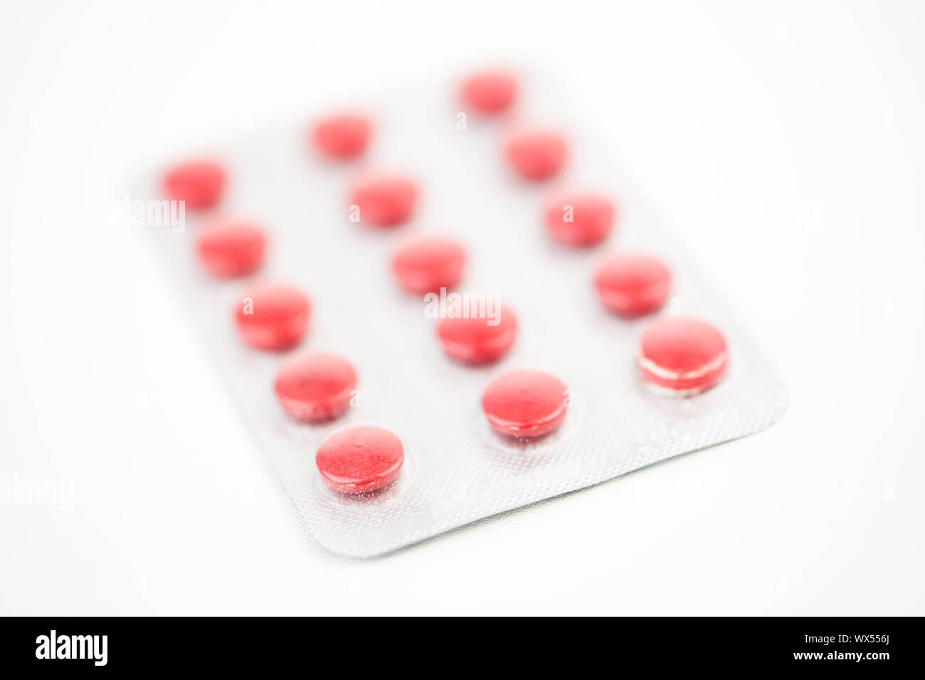 Red medications against white background Stock Photo - Alamy