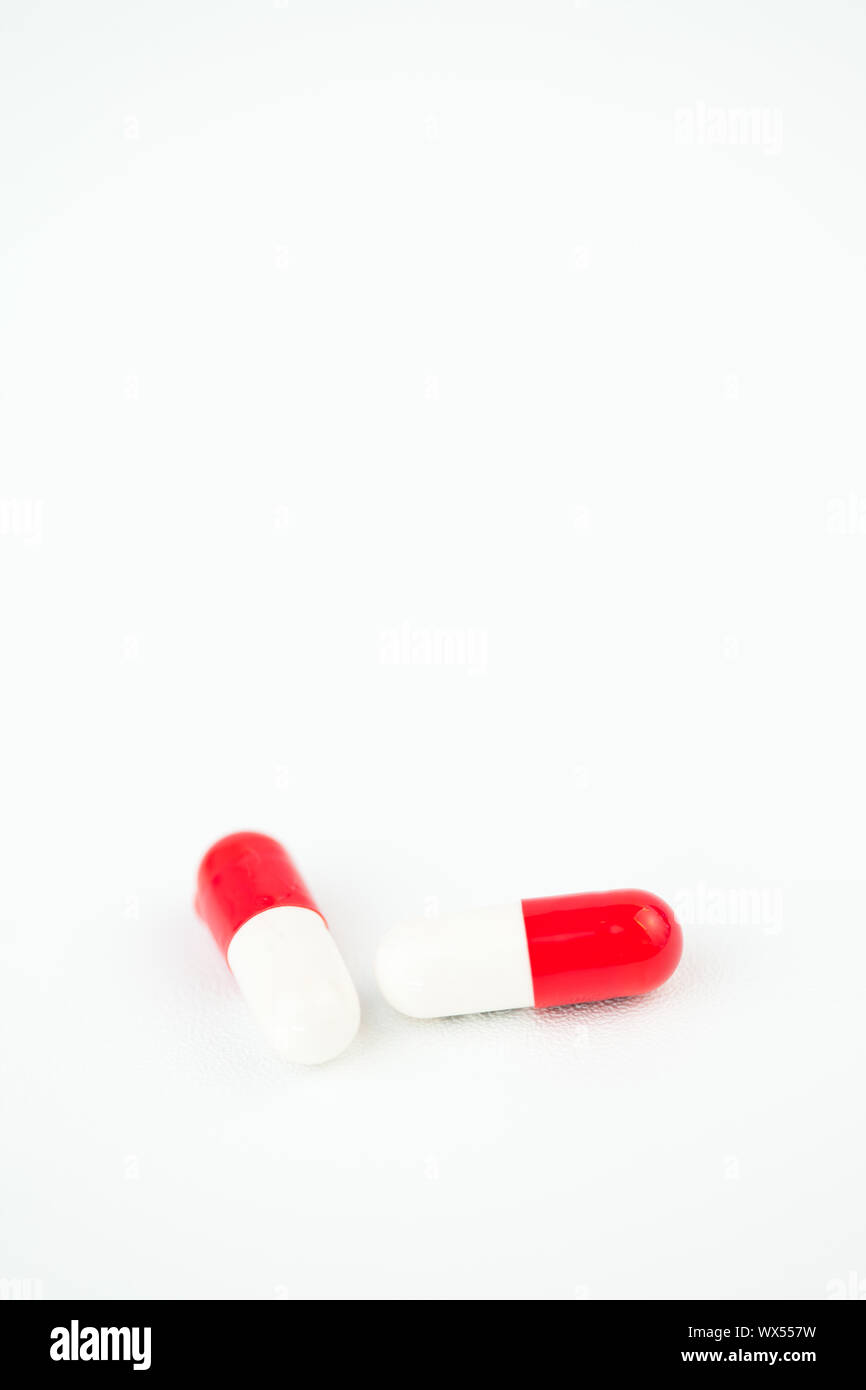 Two capsules against white background Stock Photo - Alamy