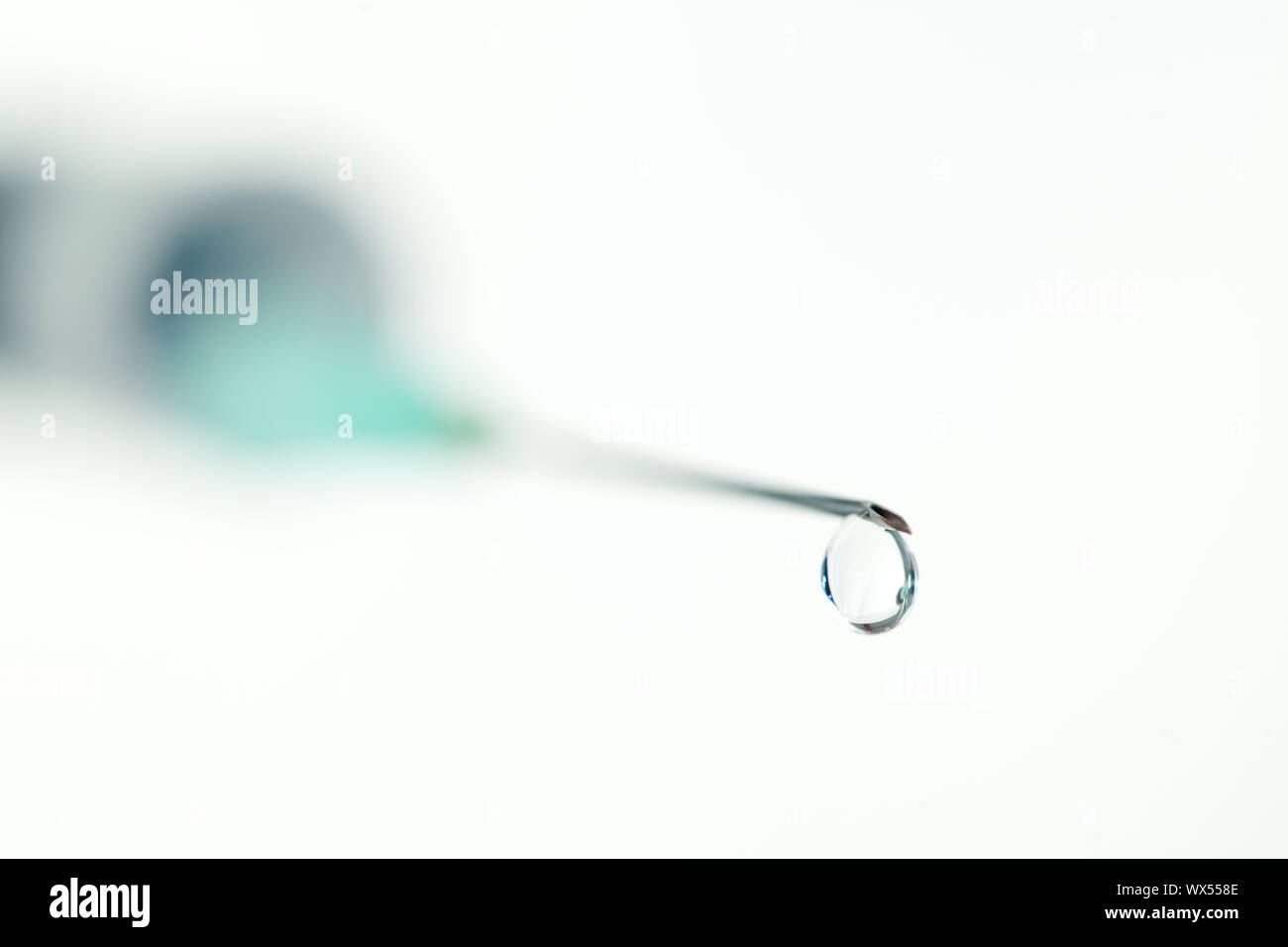 Close up of a drop outgoing of a syringe against white background Stock ...