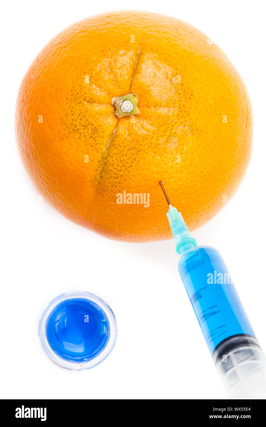 Syringe injecting blue liquid in an orange against a white background ...