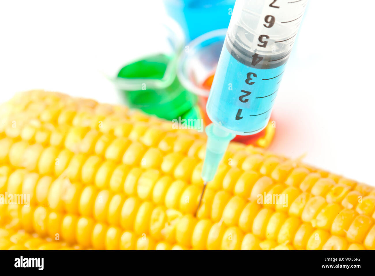 Syringe piercing corn against a white background Stock Photo - Alamy