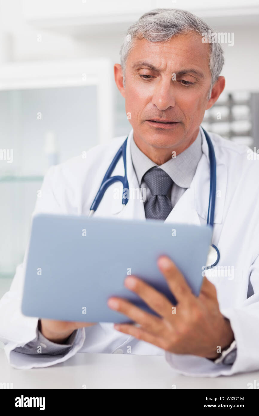 Doctor using a tablet computer in a medical office Stock Photo - Alamy