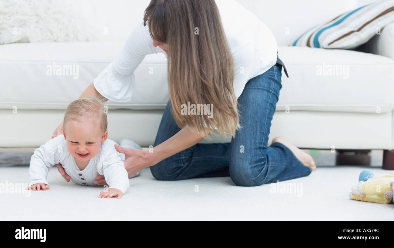 Mother catching a baby in living room Stock Photo - Alamy