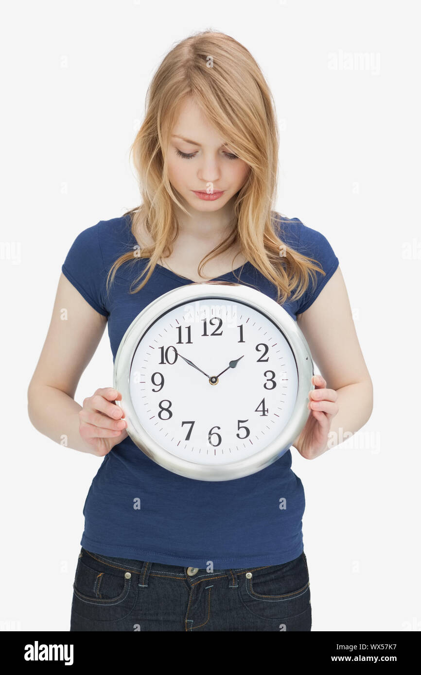 Woman looking at a clock against a white background Stock Photo - Alamy