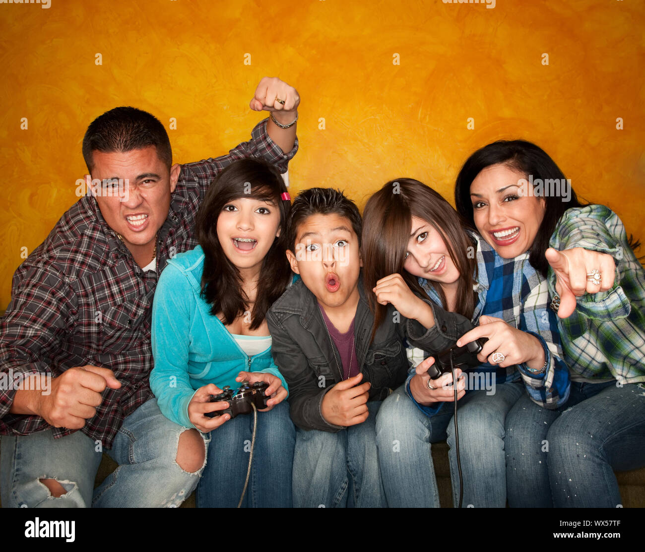 Attractive Hispanic Family on Couch Playing a Video Game Stock Photo ...