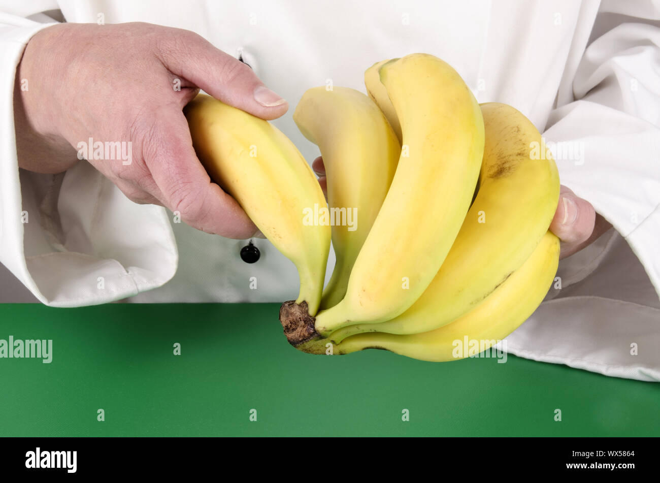 female chef holding some banana in her hands Stock Photo - Alamy