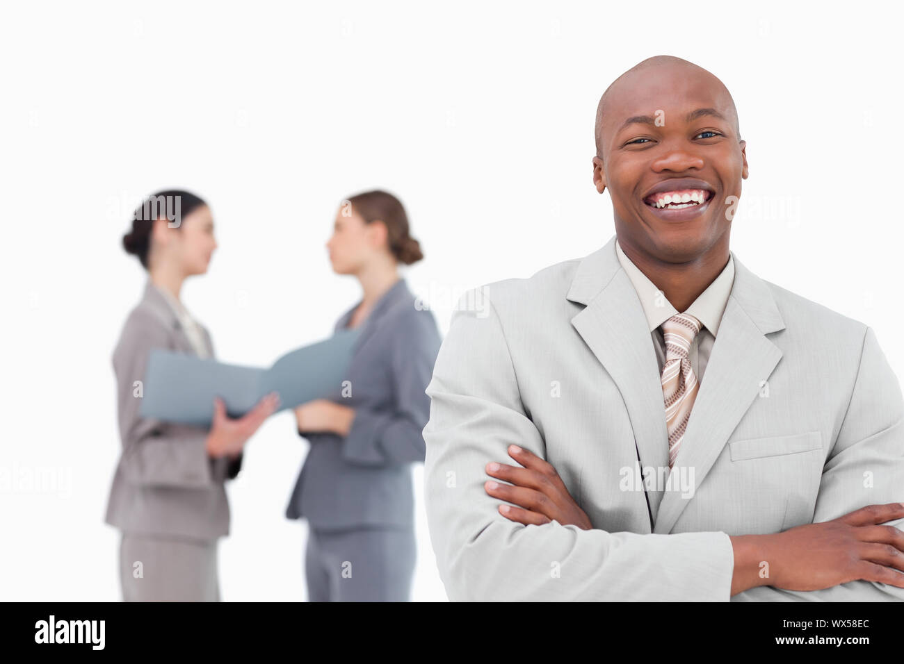 Laughing tradesman with colleagues behind him against a white ...