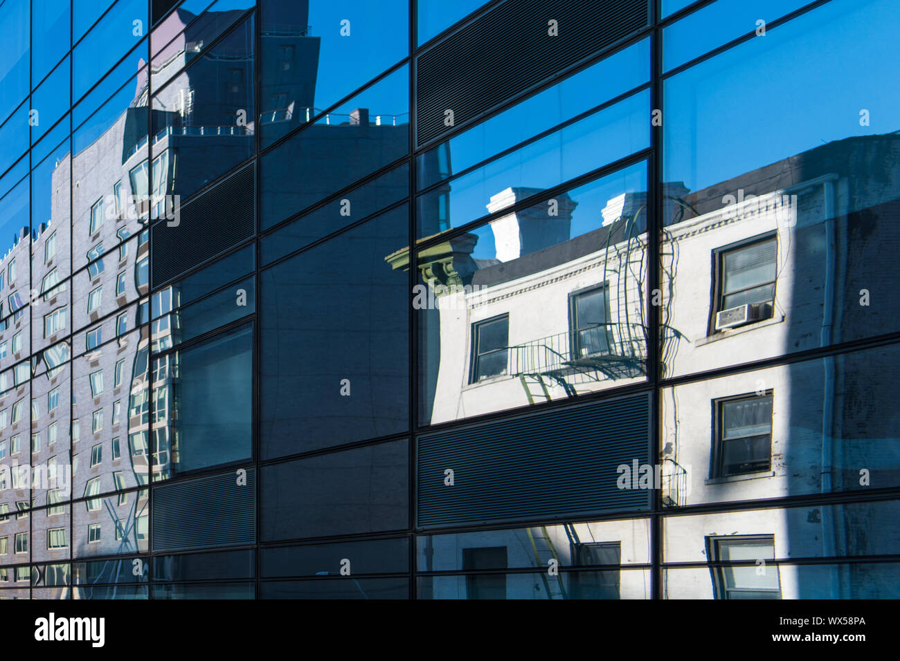 Contrast of modern and old buildings reflected in large modern glass ...