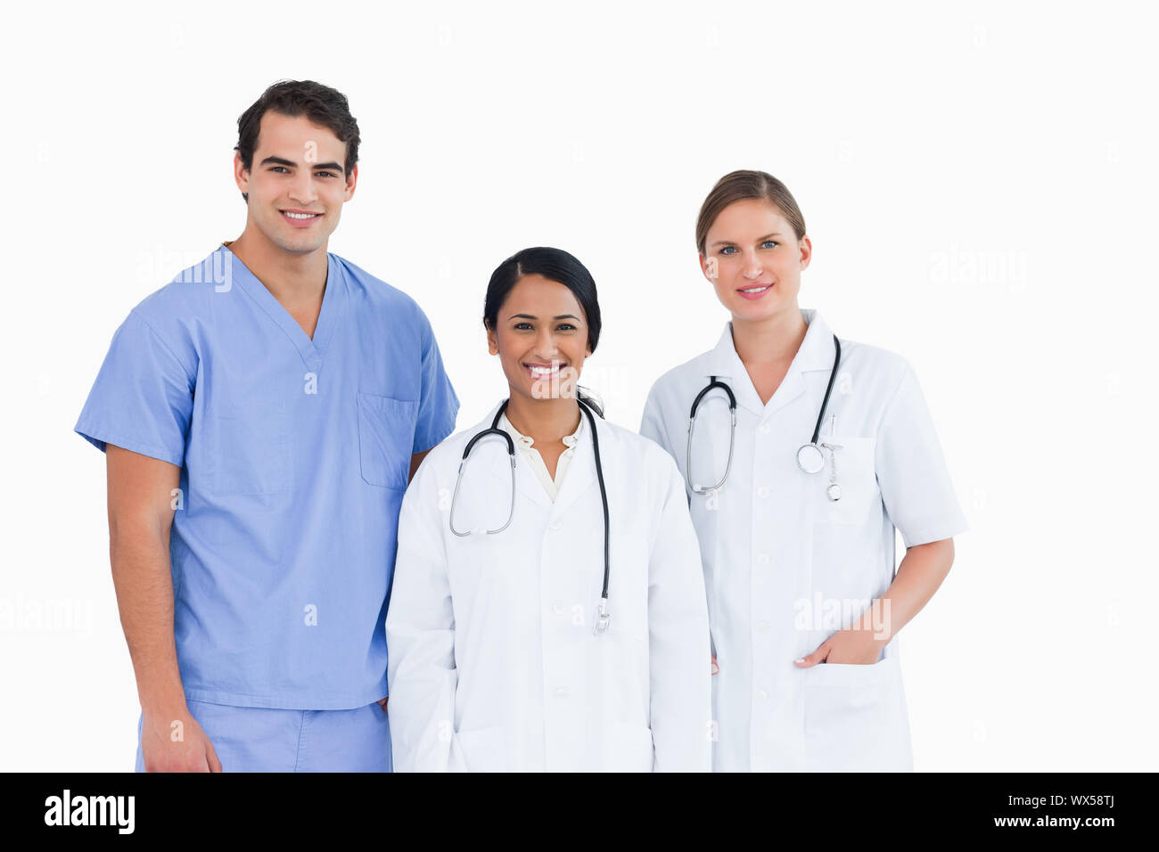 Smiling medical staff standing together against a white background ...