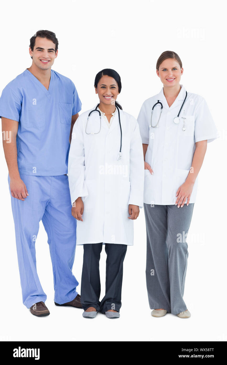 Smiling young medical staff standing together against a white ...