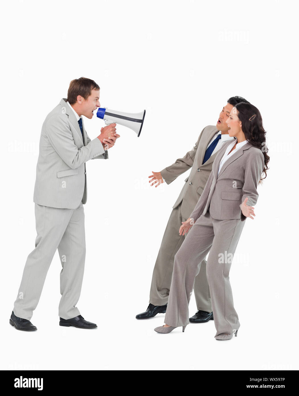 Businessman with megaphone yelling at associates against a white ...