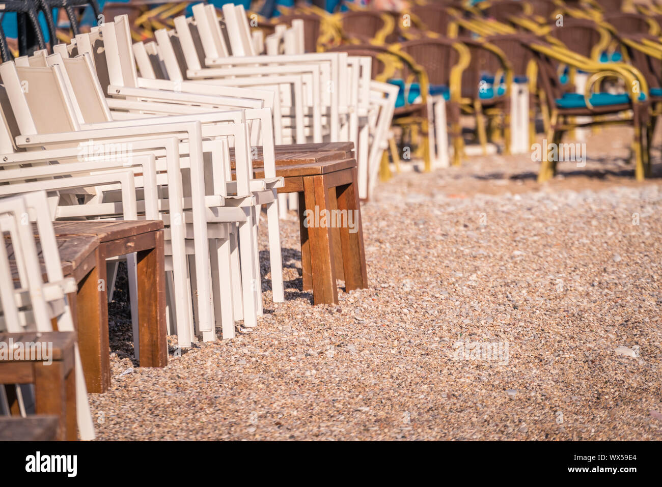 Wooden chairs piled up on the beach Stock Photo - Alamy