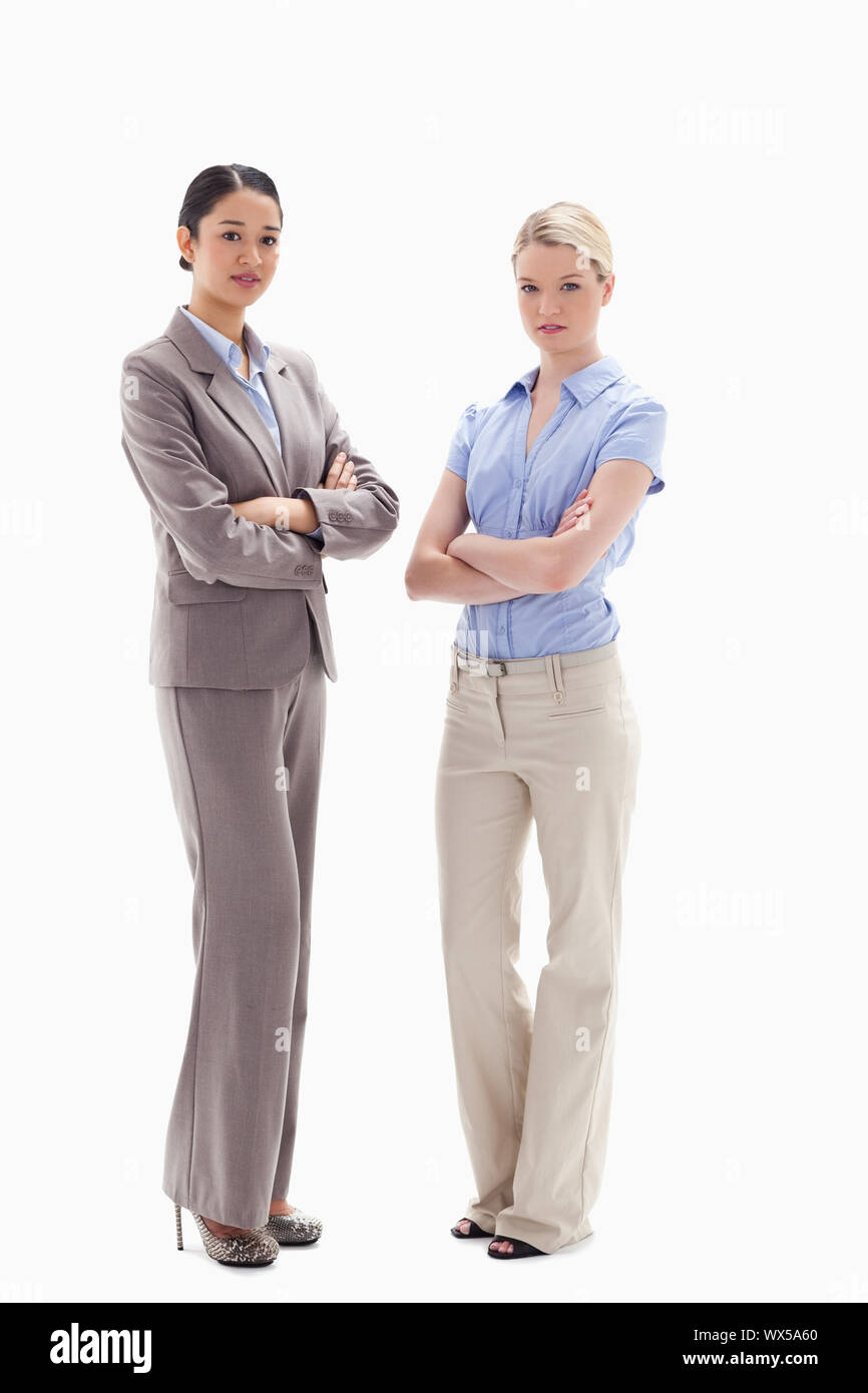Two serious women crossing their arms against white background Stock ...