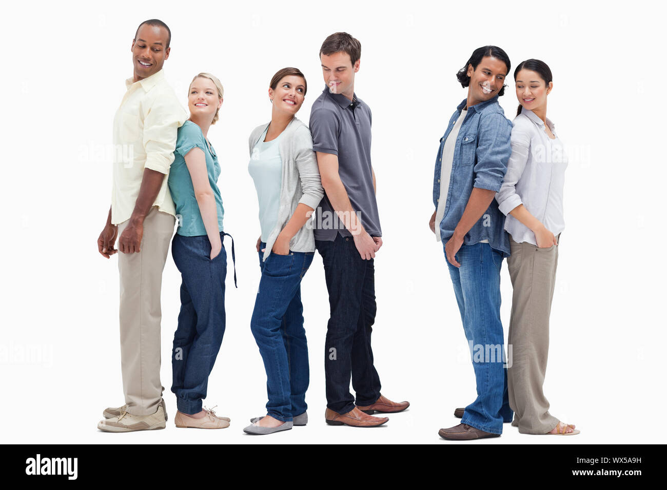Three couples standing back to back looking at each other against white ...