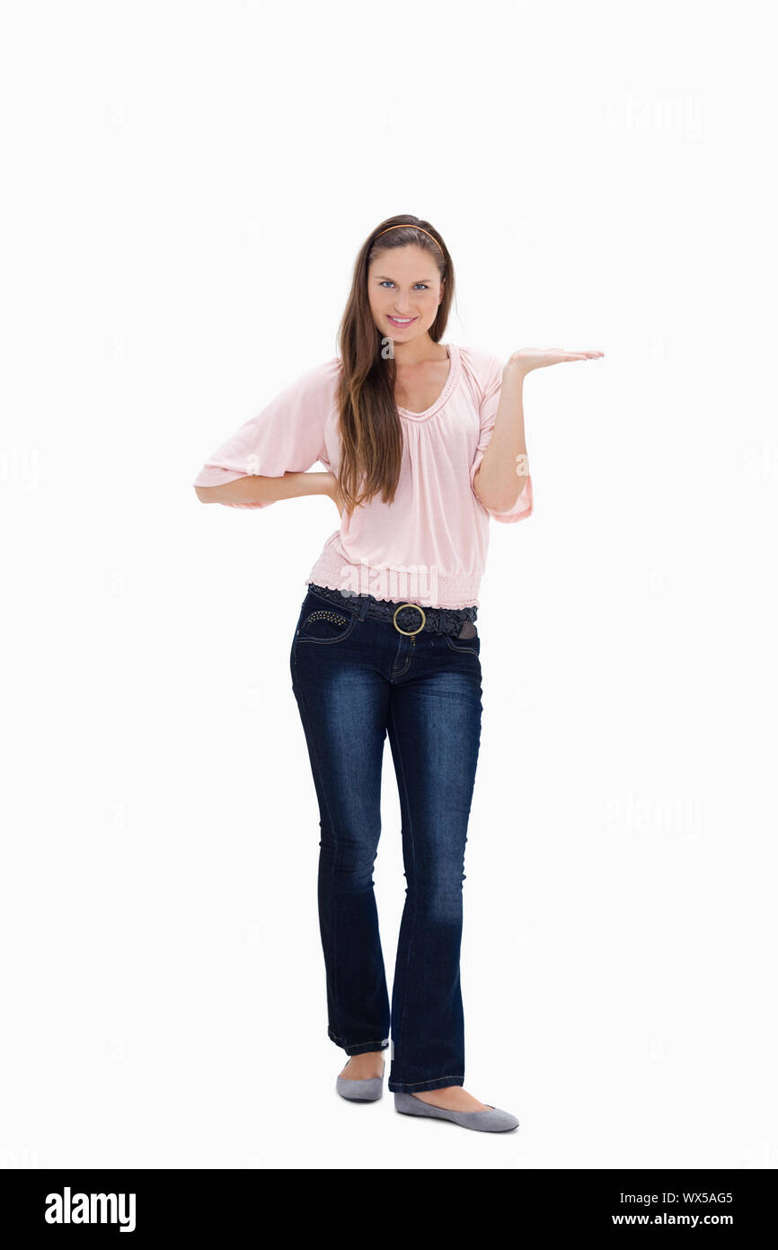 Young woman presenting with her hand on her hip against white ...