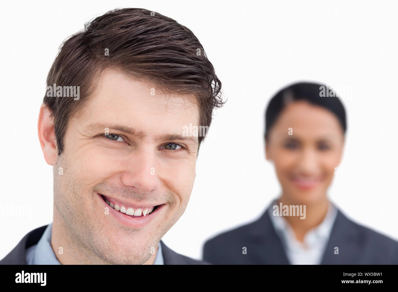 Close up of smiling salesman with colleague behind him Stock Photo - Alamy