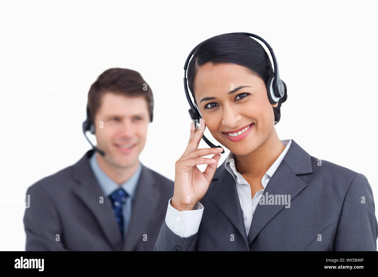 Close up of smiling call center agent with colleague behind her Stock ...