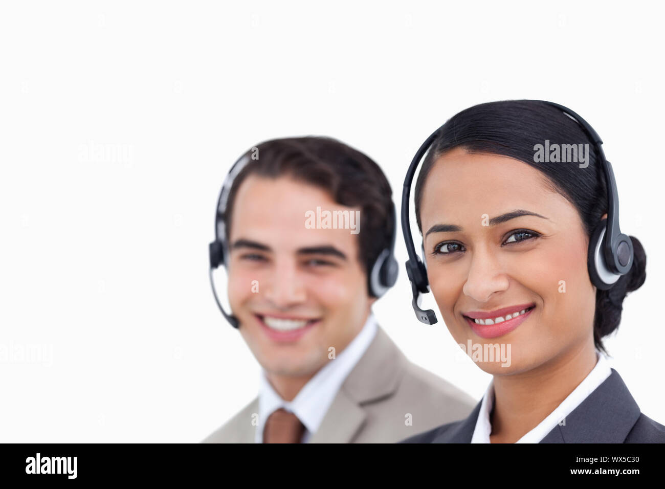 Close up side view of smiling telephone support employees at work ...