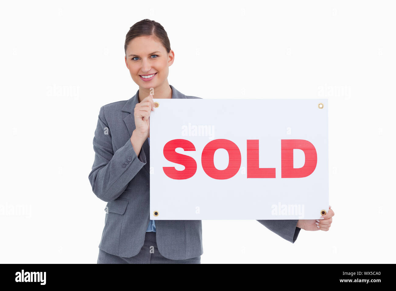 Smiling real estate agent holding sold sign Stock Photo - Alamy