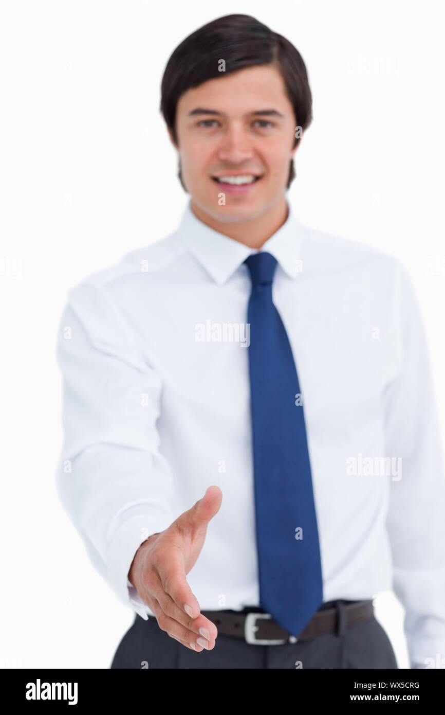 Hand offered by smiling young tradesman against a white background ...