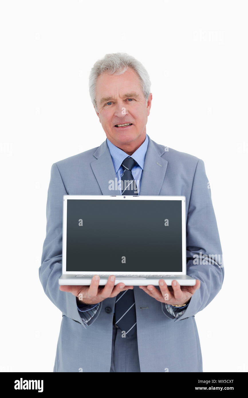 Mature tradesman presenting screen of his laptop against a white ...