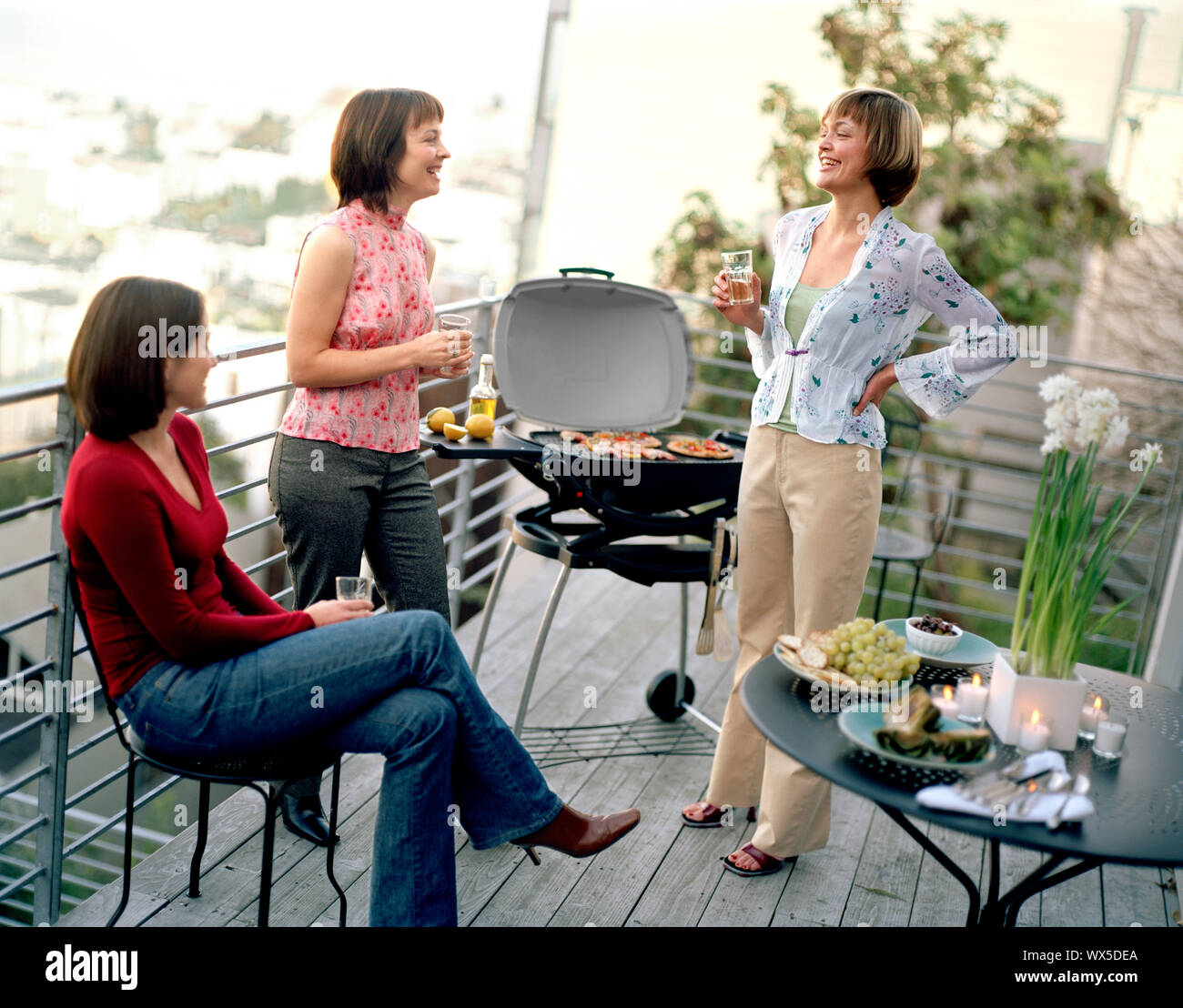 Three young ladies at a barbecue party in a balcony Stock Photo - Alamy