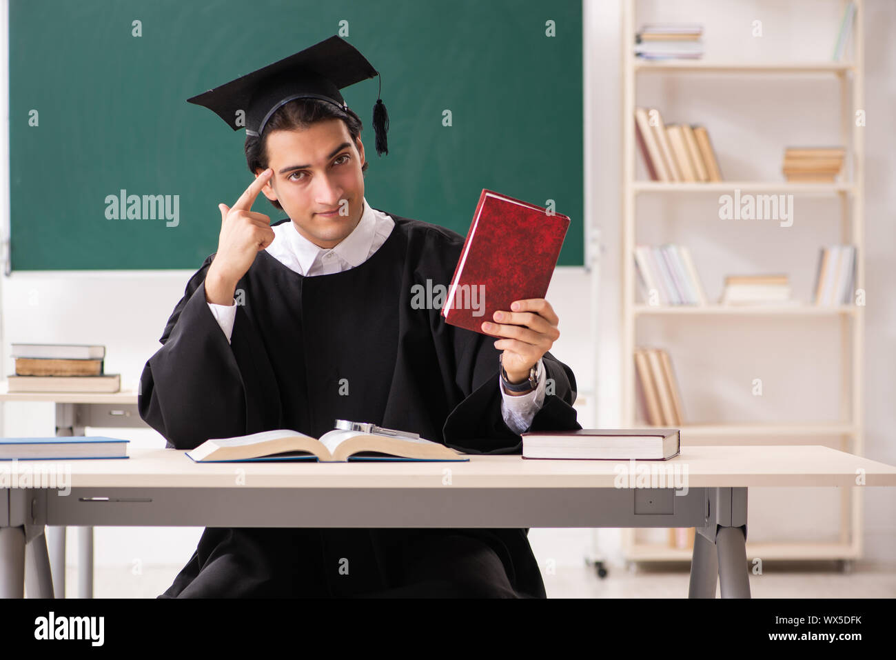 Graduate student in front of green board Stock Photo - Alamy