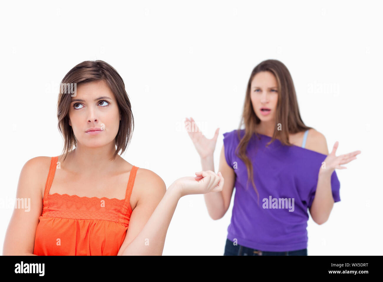 Teenager standing upright while her friend is shouting at her Stock ...
